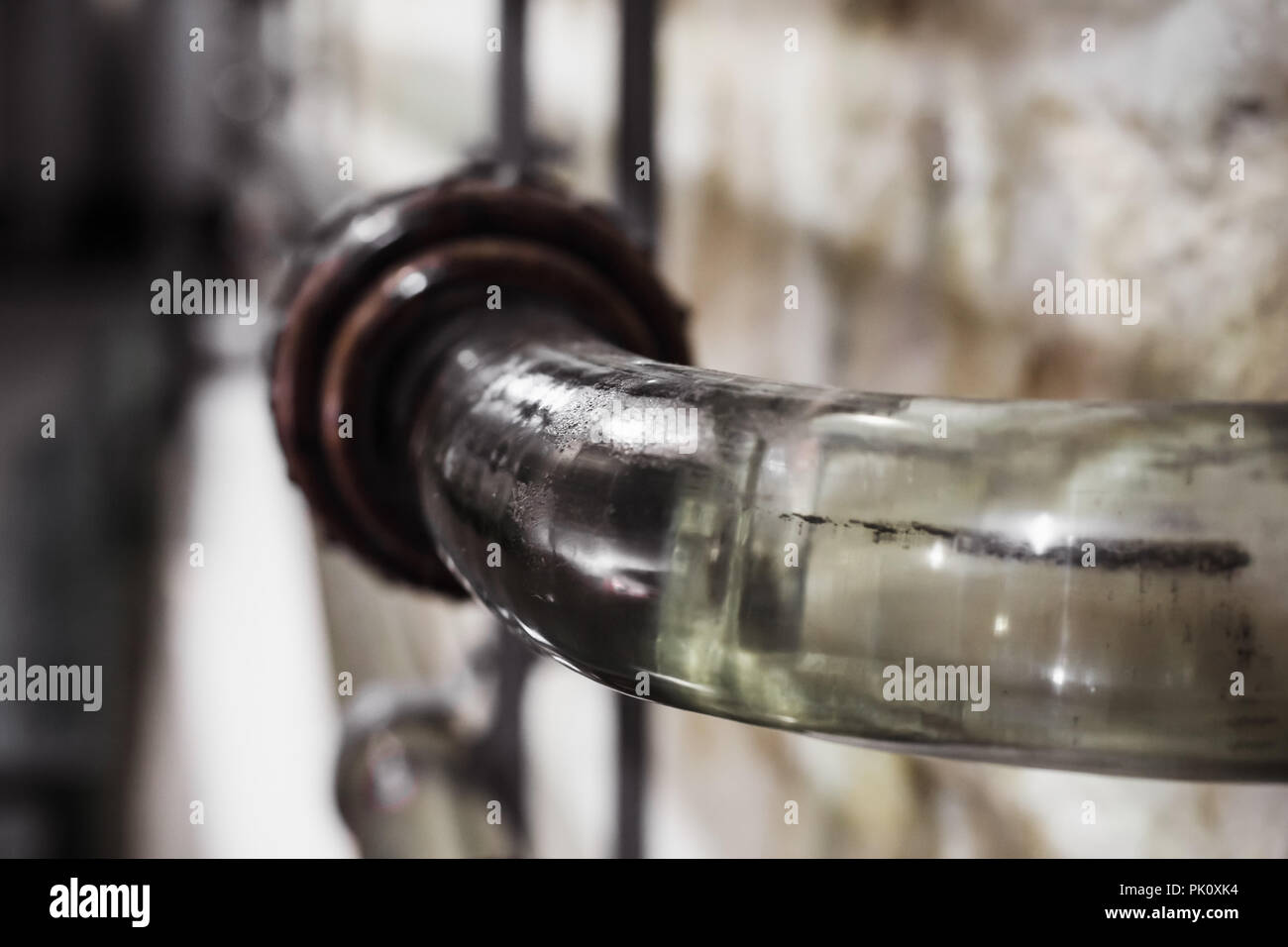 Close-up photo of glass pipeline for pumping wine at the winery ...