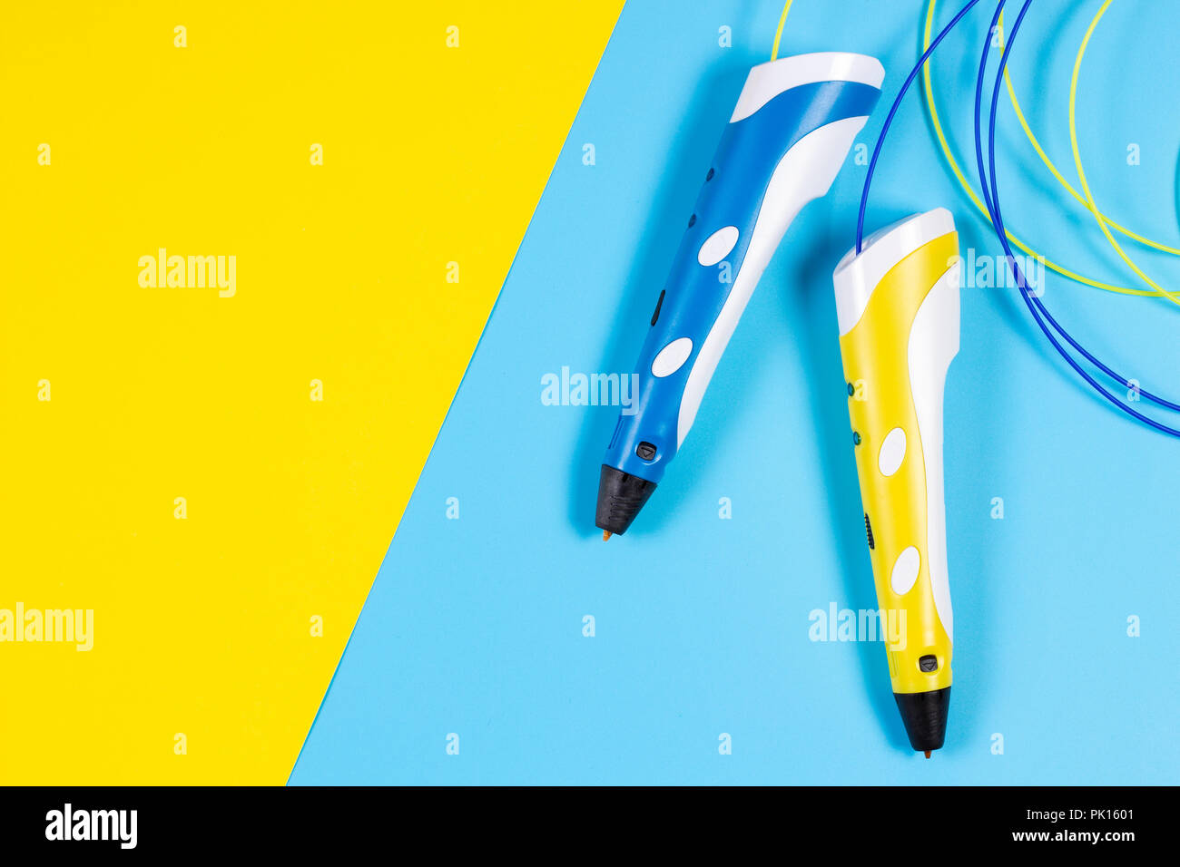 3d pens with colourful plastic filament on blue and yellow background ...