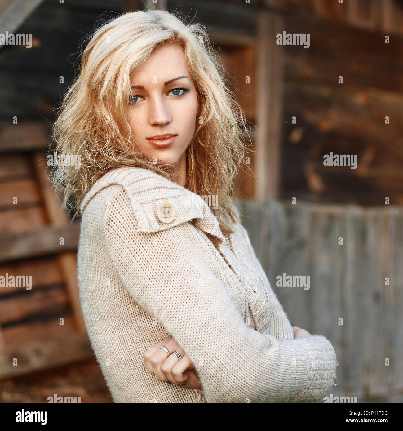 Portrait of a beautiful rural girl with blue eyes. On the background of ...