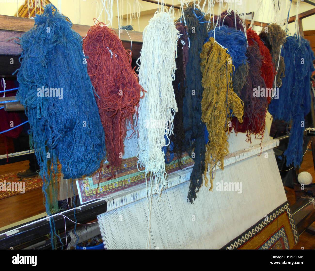 Some of the colourful wool used in the weaving of carpets at a workshop ...