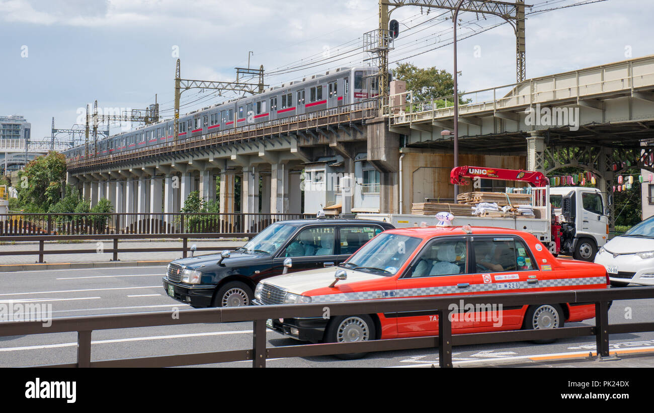 Tokyo, Japan - September 8, 2018: A train cuts across the road at a ...
