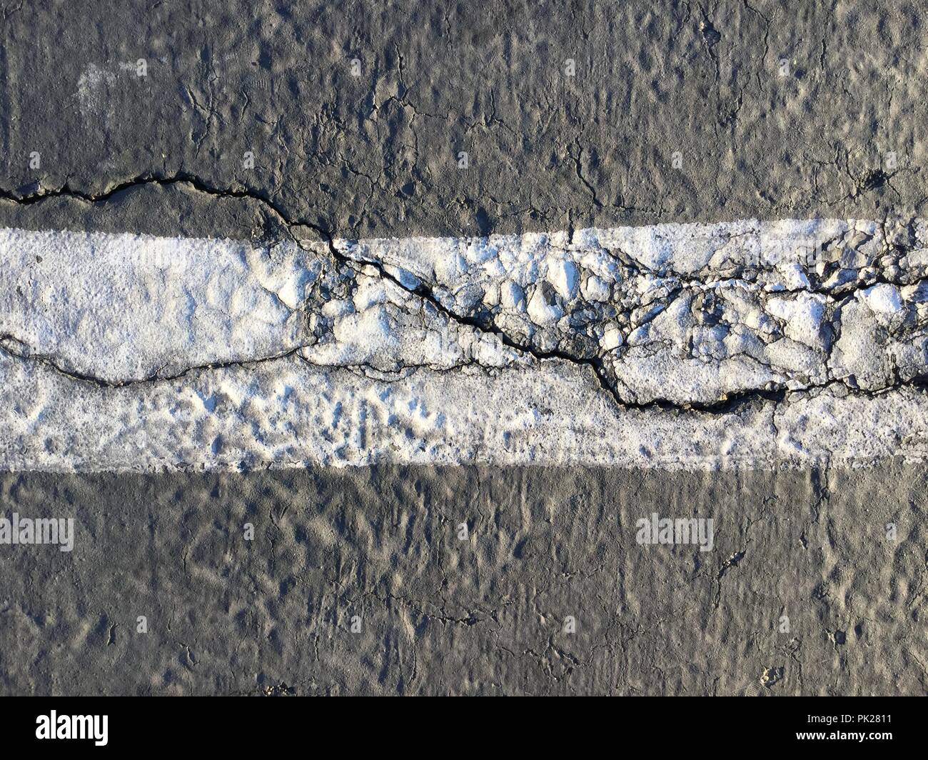 Asphalt with white line and cracks Stock Photo - Alamy