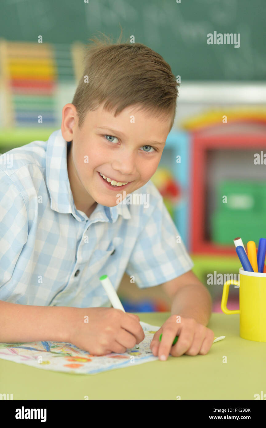 Portrait of cute little boy drawing in classroom Stock Photo - Alamy