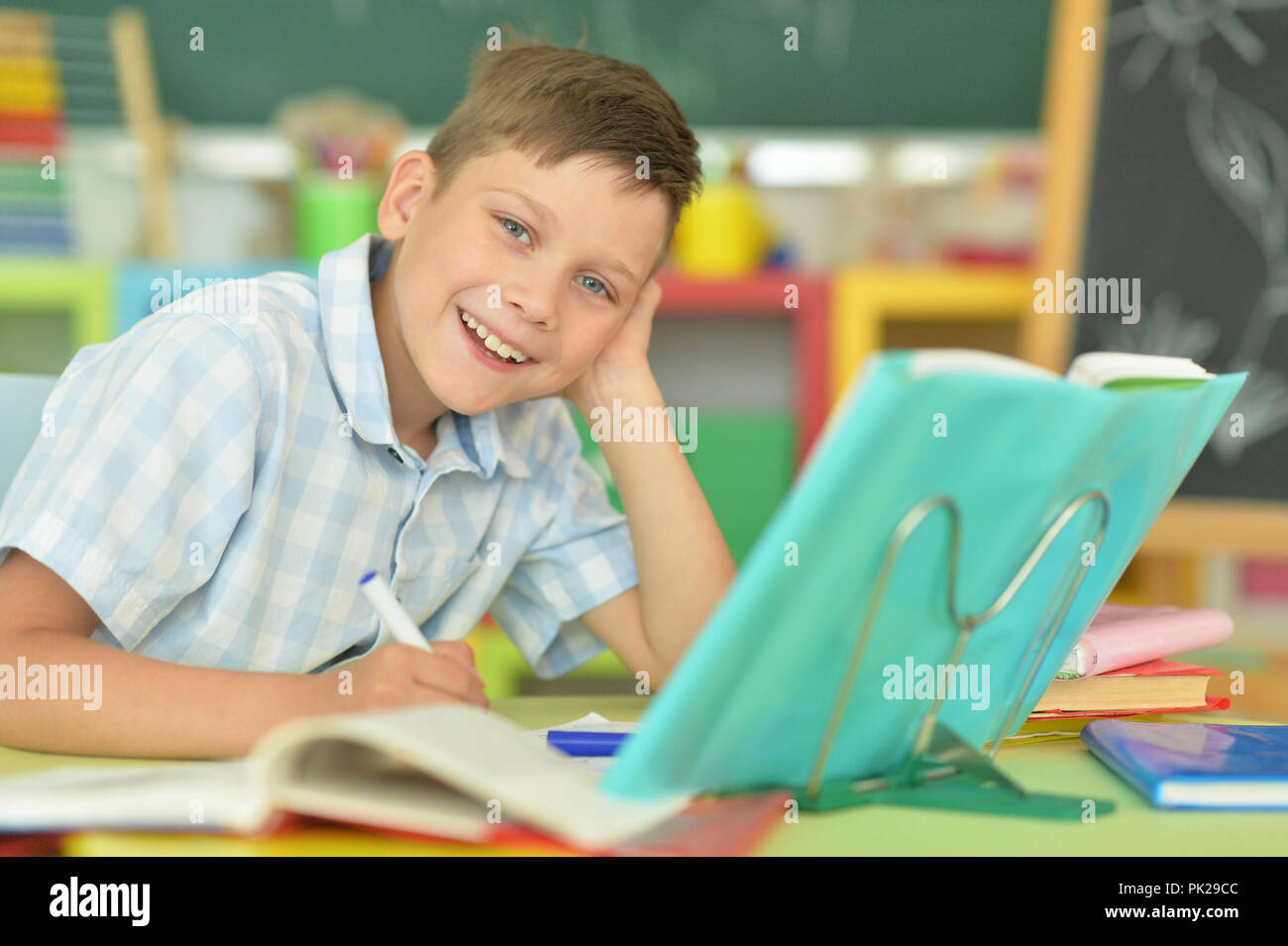 boy doing homework at desk in classroom Stock Photo - Alamy