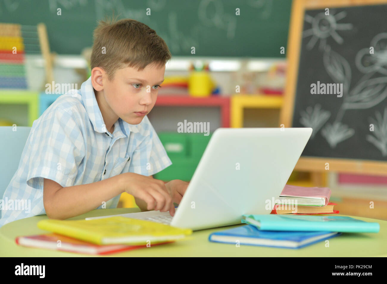 Portrait of boy doing homework in classroom Stock Photo - Alamy