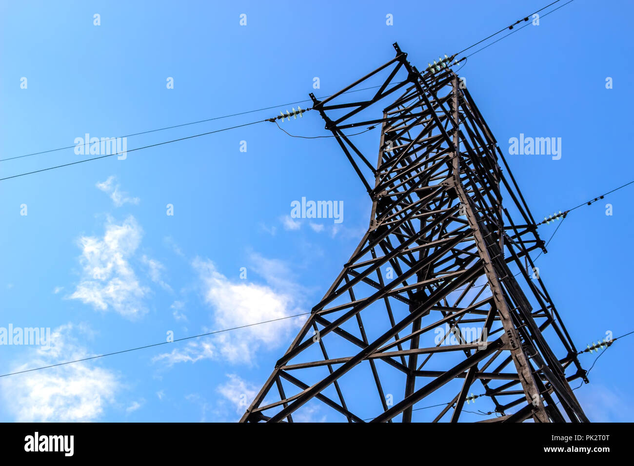 Power line support against blue sky background Stock Photo - Alamy