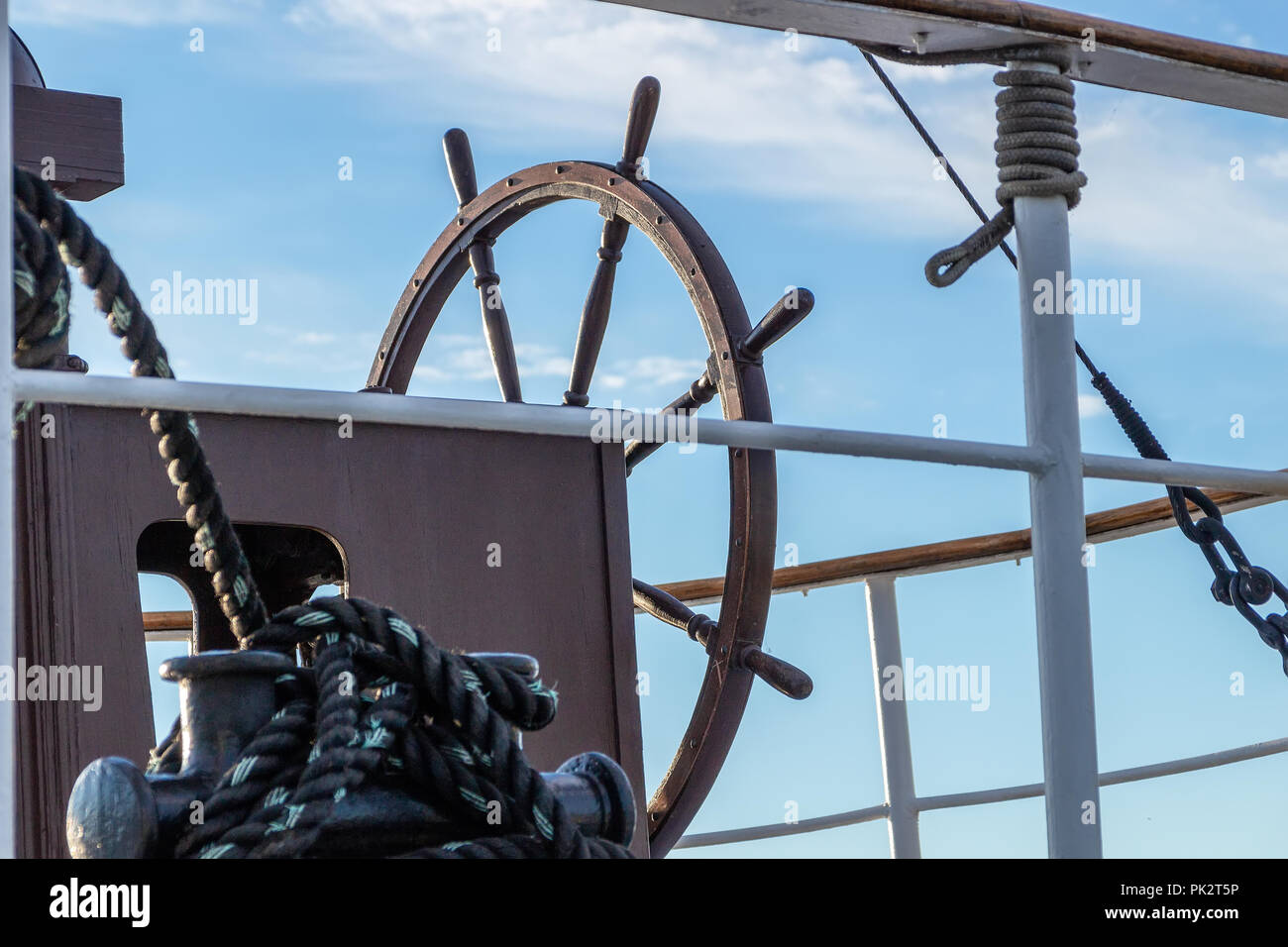 Steering wheel ship on blue sky background Stock Photo - Alamy