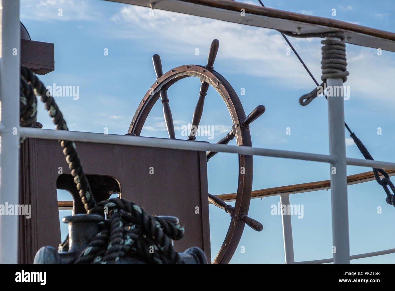 Steering wheel ship on blue sky background Stock Photo - Alamy