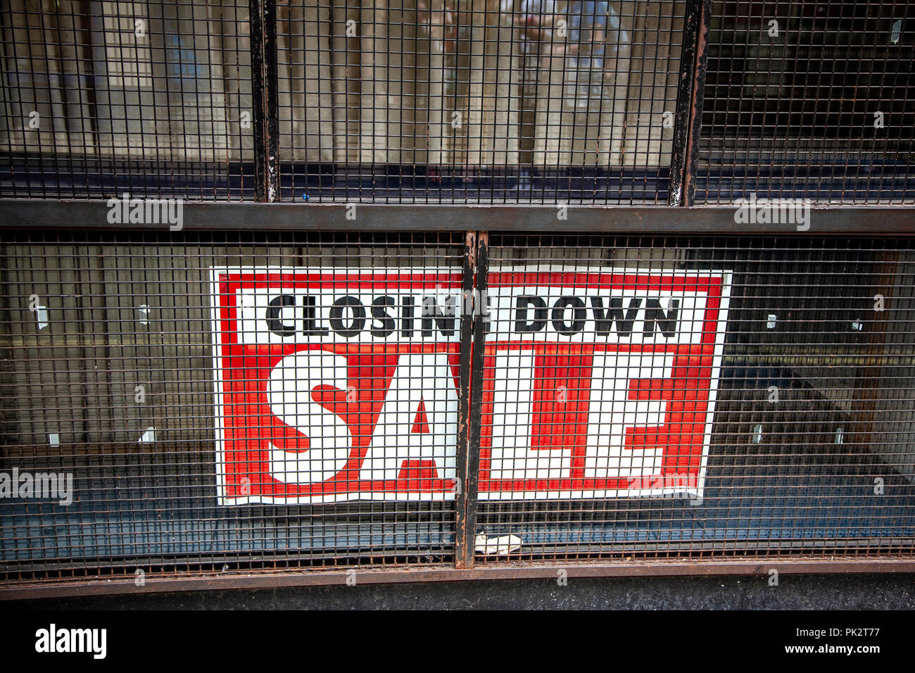 Closing down sign in shop front window behind security bars Stock Photo ...