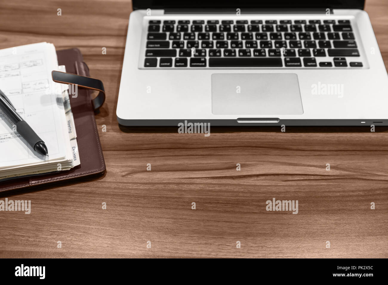 Office desktop. On the desk is a laptop, a notebook with notes and a ...