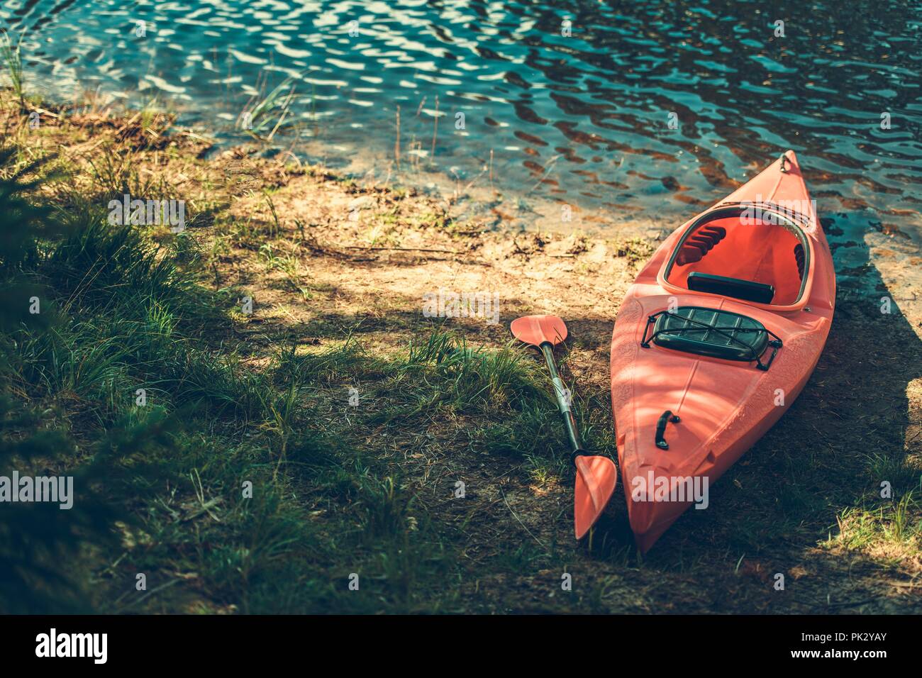 Summer Kayak Trip. Red Plastic Kayak on the Lake Shore Stock Photo - Alamy