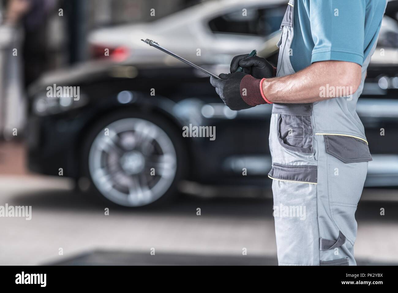 Caucasian Auto Service Worker with Documentation. Vehicles Maintenance ...