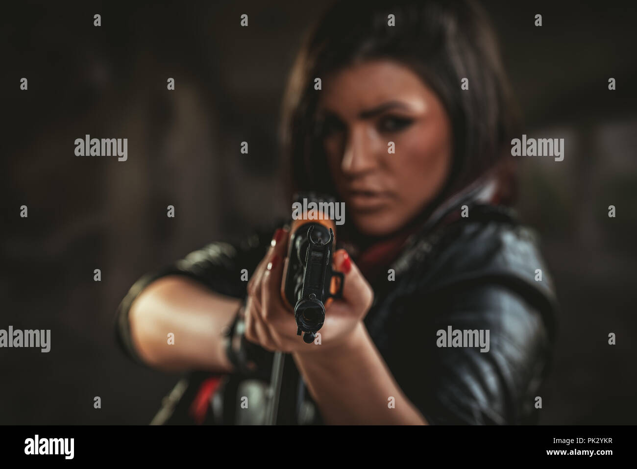 Attractive girl standing in the attitude of aiming and looking through ...