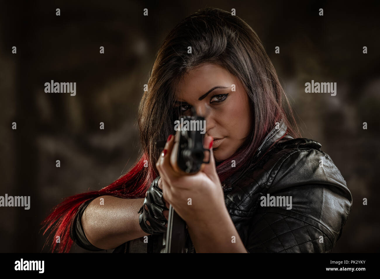 Attractive girl standing in the attitude of aiming and looking through ...