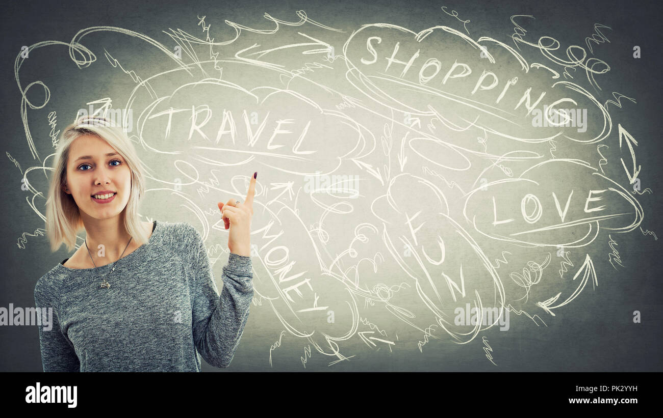 Portrait of casual young woman pointing finger up planning her future ...