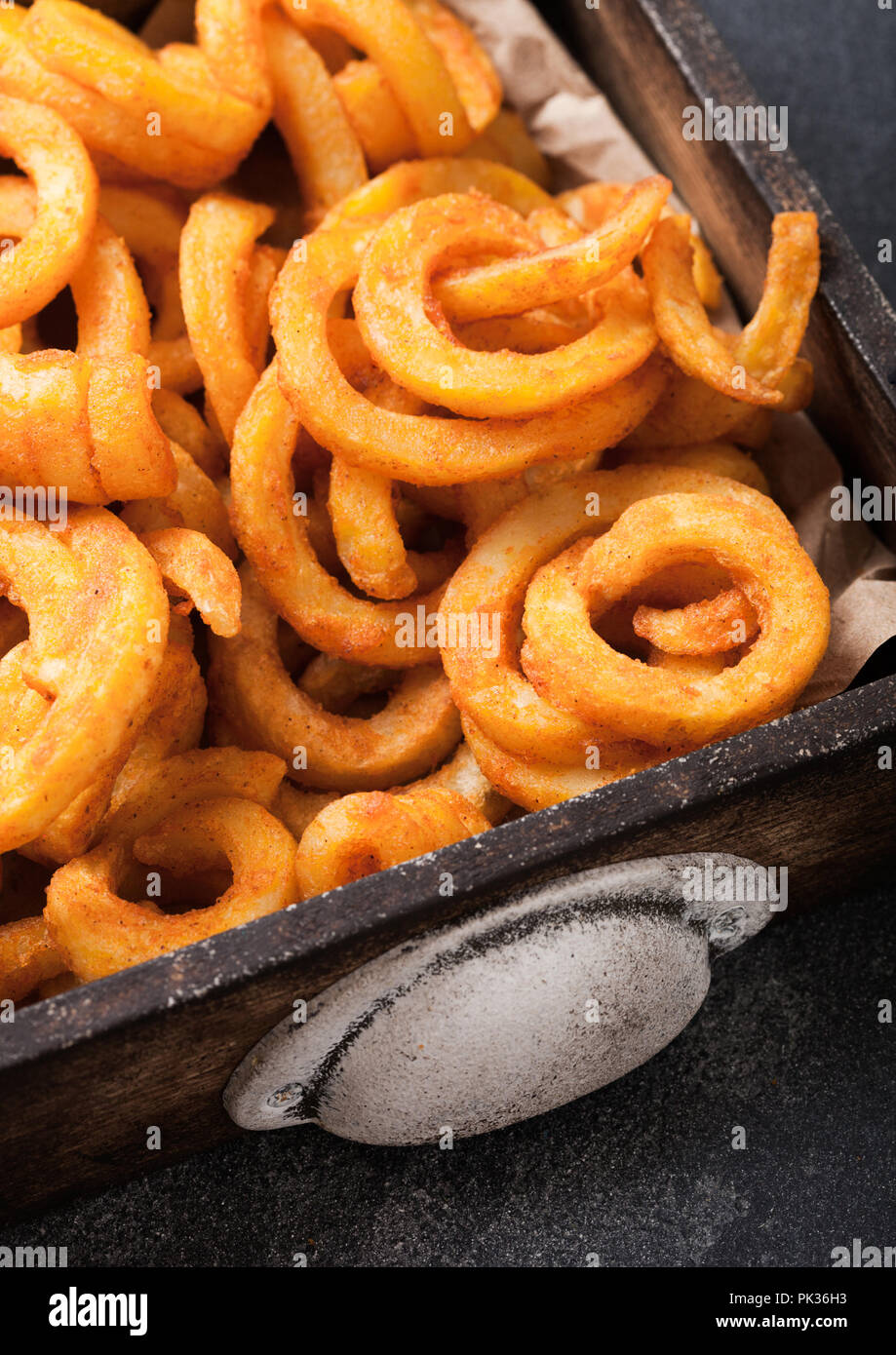 Curly fries fast food snack in wooden box on kitchen background ...
