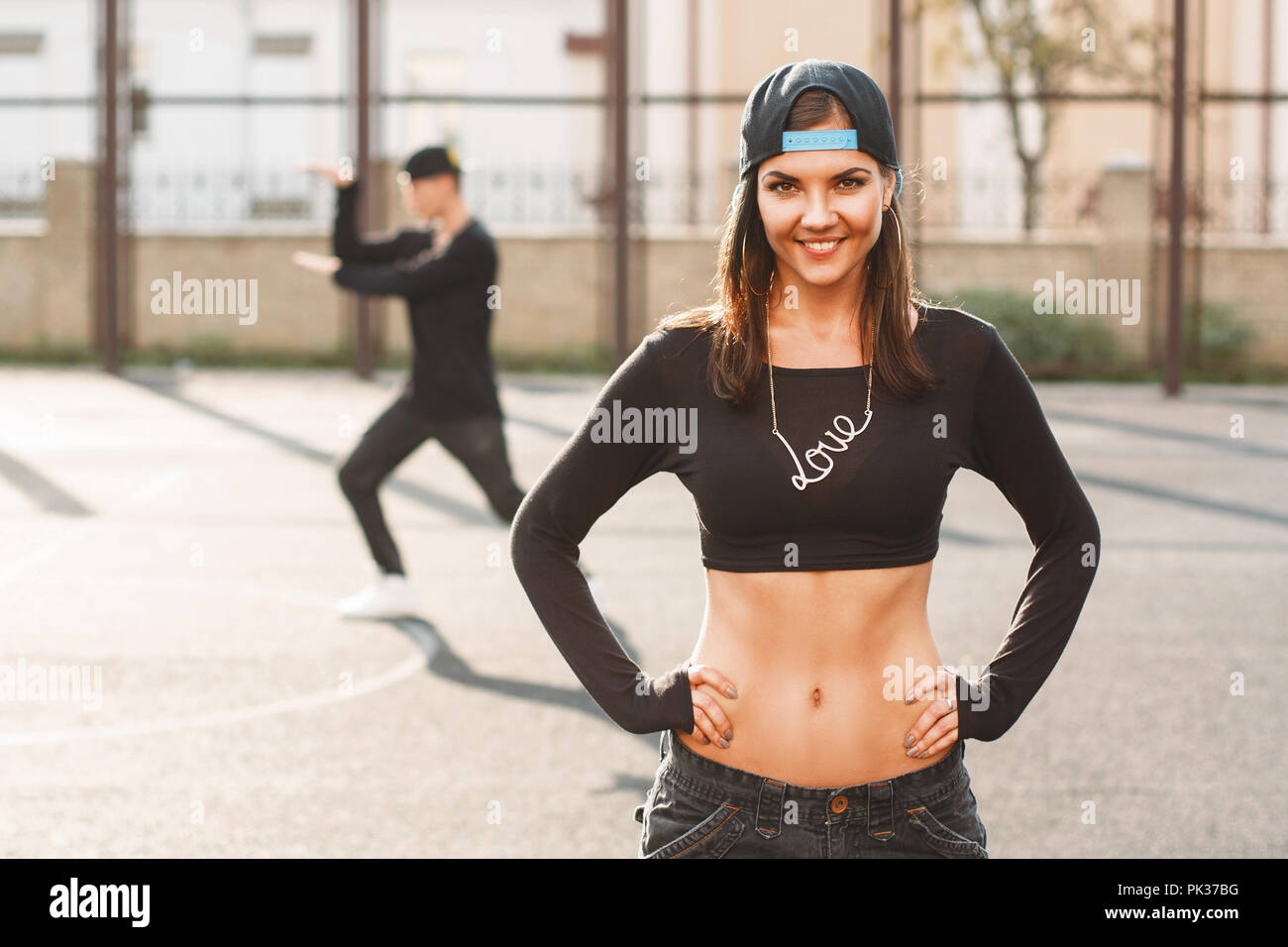 Hip-hop dancer woman in stylish black dress with chain "Loves" and a ...