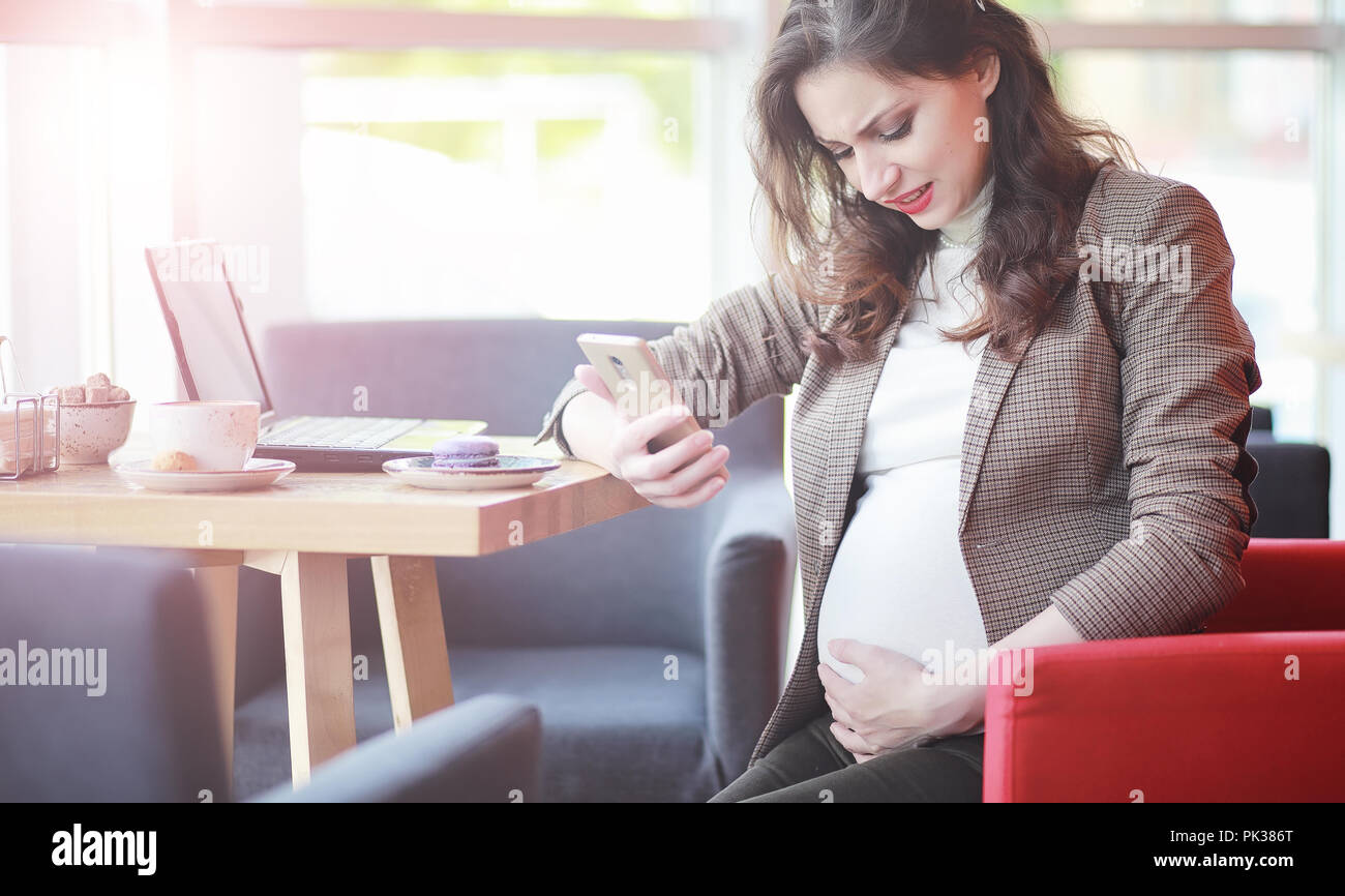 Pregnant woman working on computer in cafe Stock Photo - Alamy