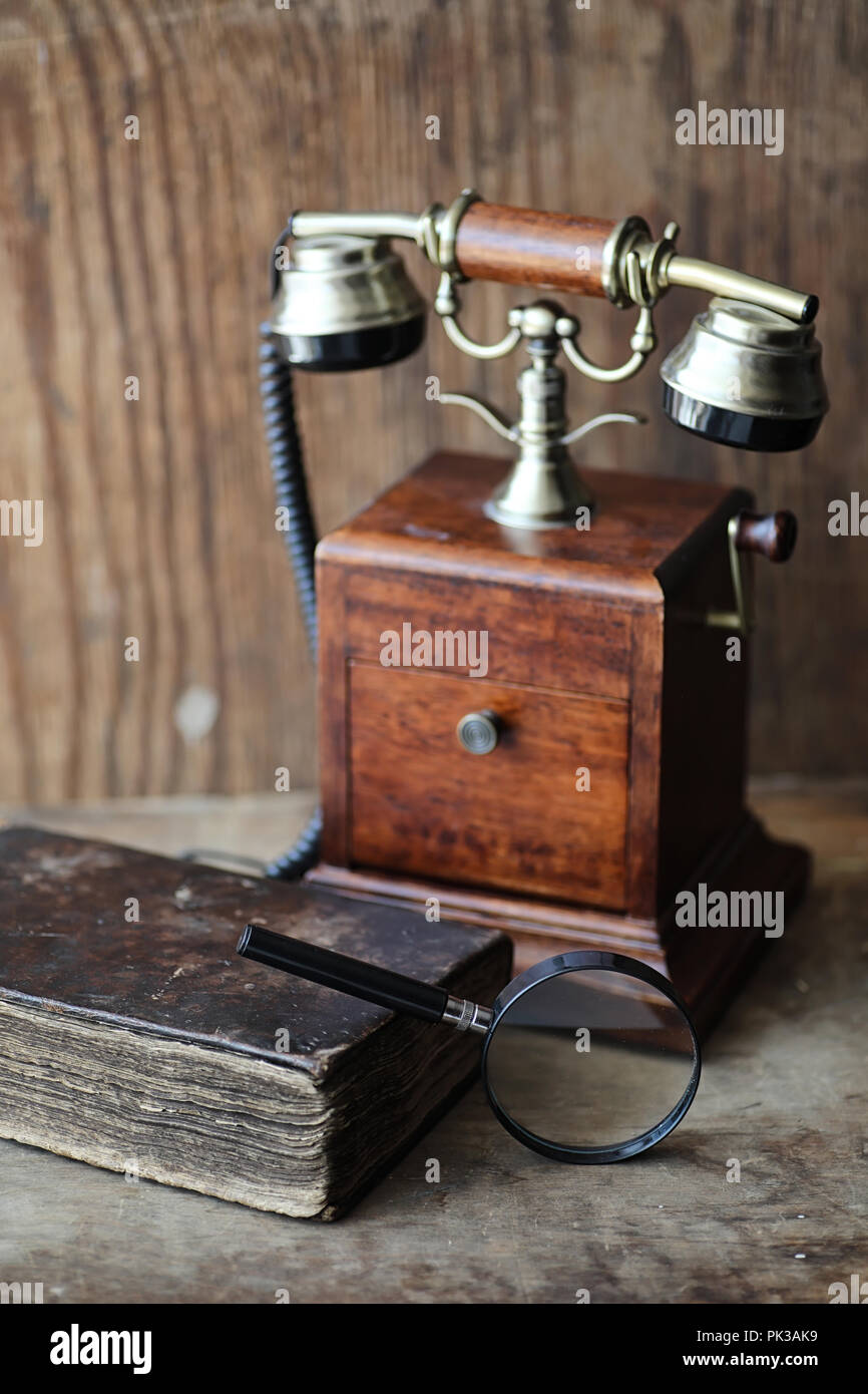 Old telephone and retro book on a wood Stock Photo - Alamy