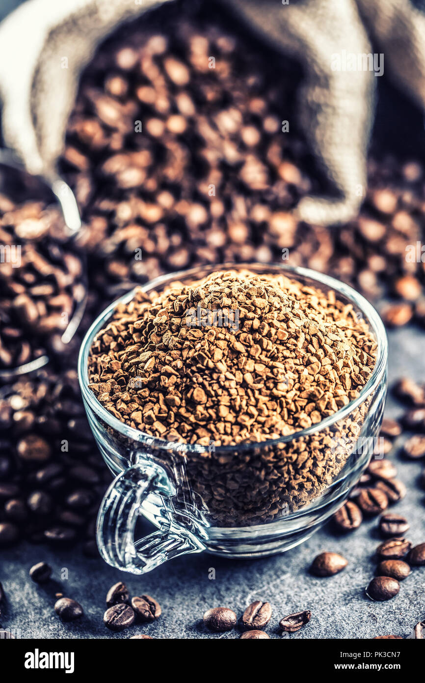 Granules of instant coffee in glass cup and coffee beans Stock Photo ...