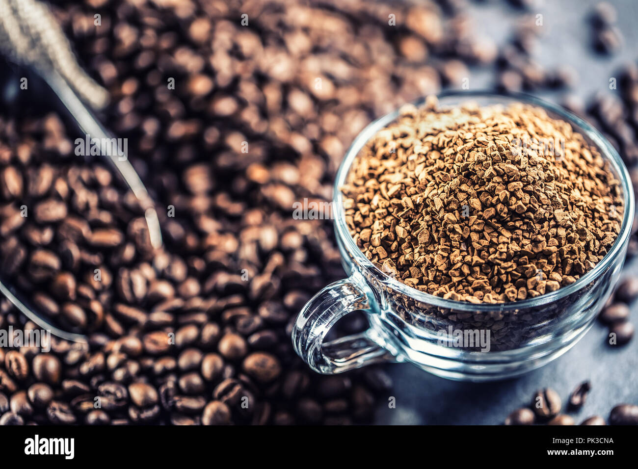 Granules of instant coffee in glass cup and coffee beans Stock Photo ...