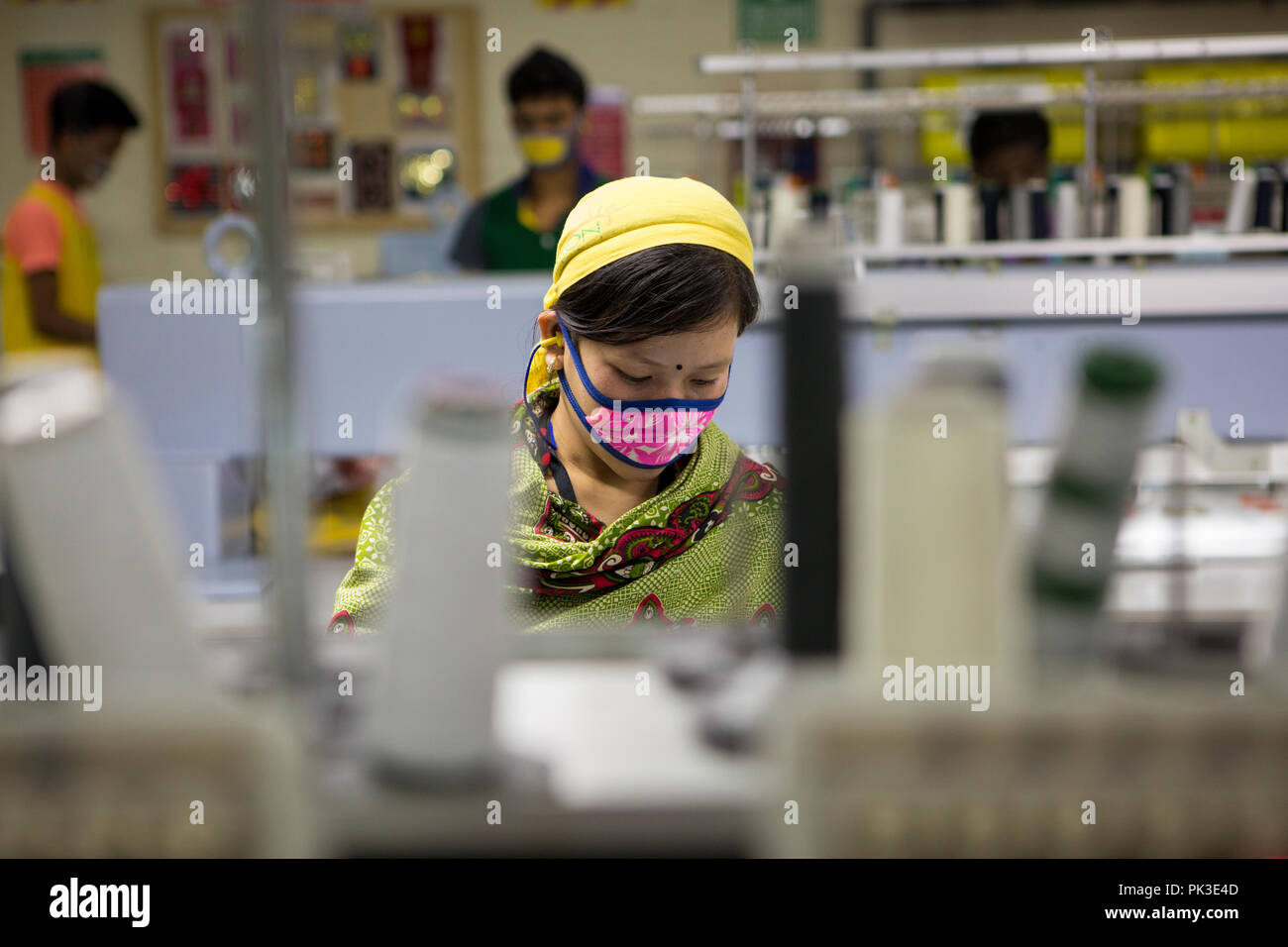 A garment worker at work on a machine inside a garment factory in ...