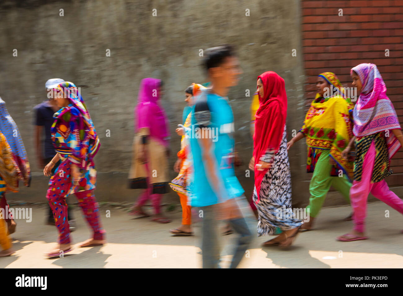 A colourful flow of garment workers walking to work in Bangladesh Stock ...