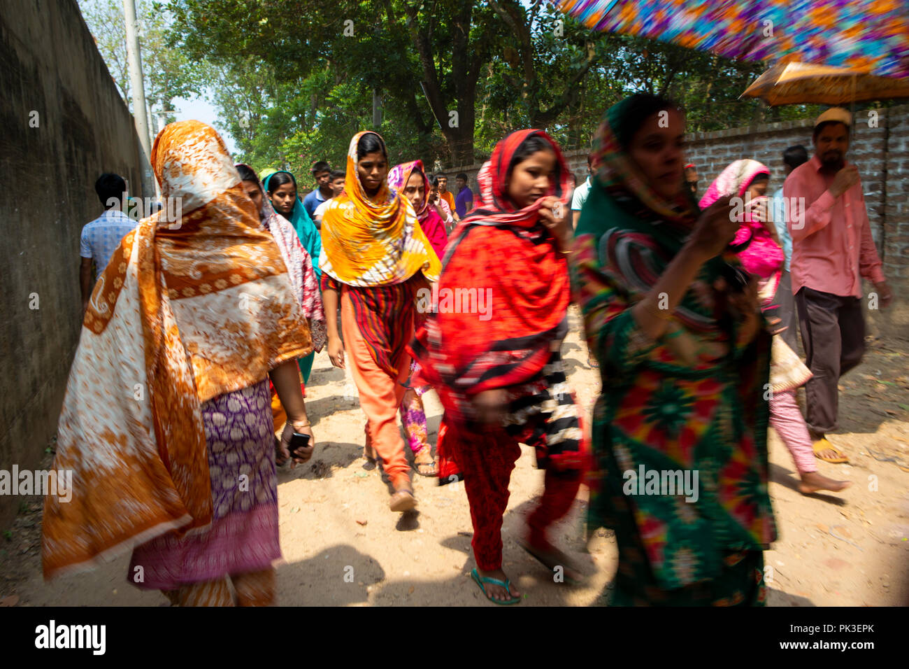 A colourful flow of garment workers walking to work in Bangladesh Stock ...