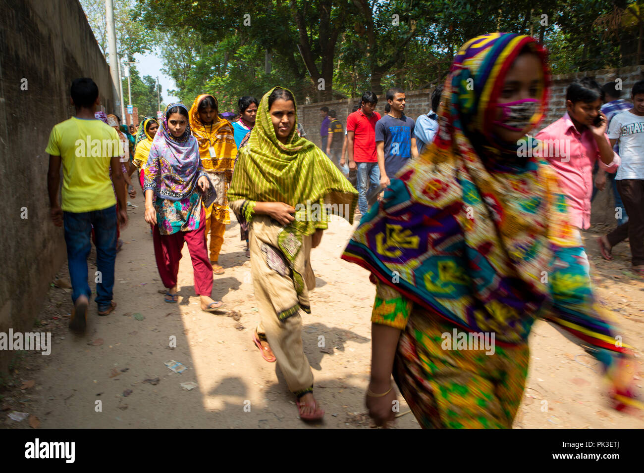 A colourful flow of garment workers walking to work in Bangladesh Stock ...