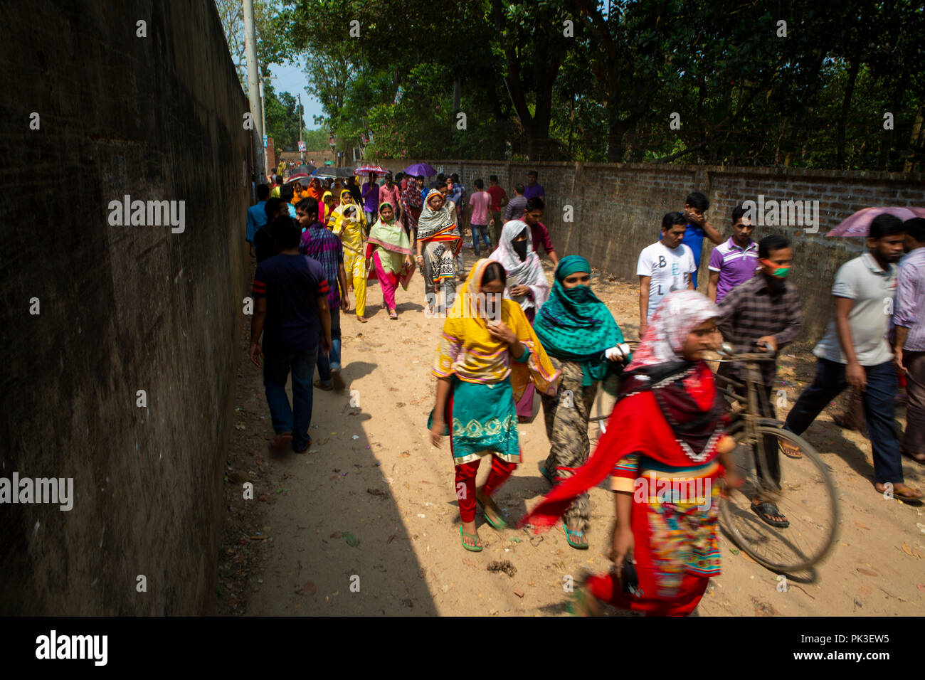 A colourful flow of garment workers walking to work in Bangladesh Stock ...