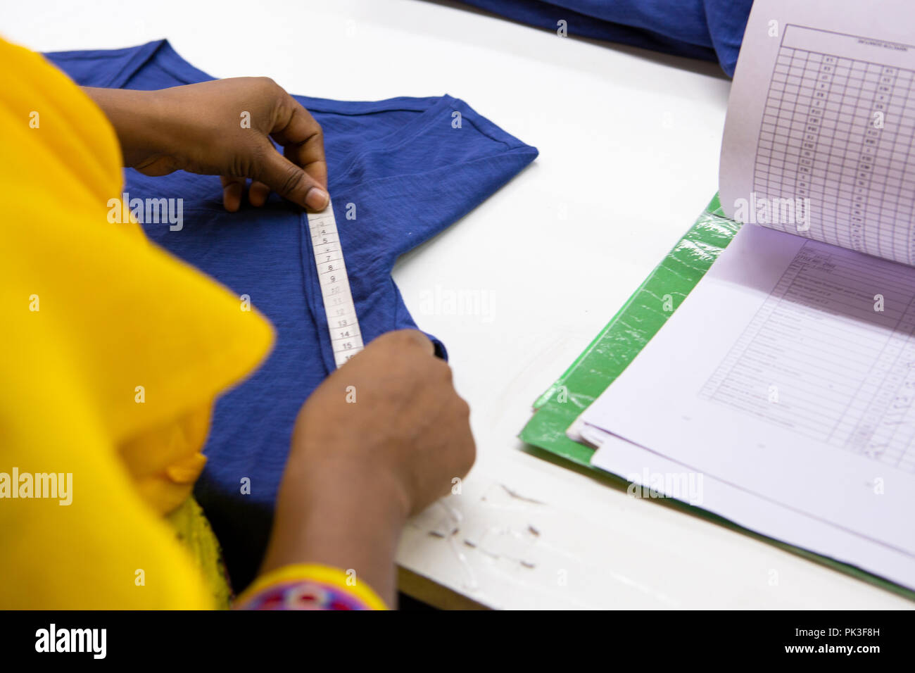 Clothes being measured and checked inside a garment factory in ...