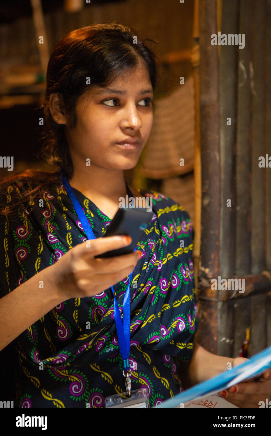 A garment worker using a mobile phone to share feedback on the working ...