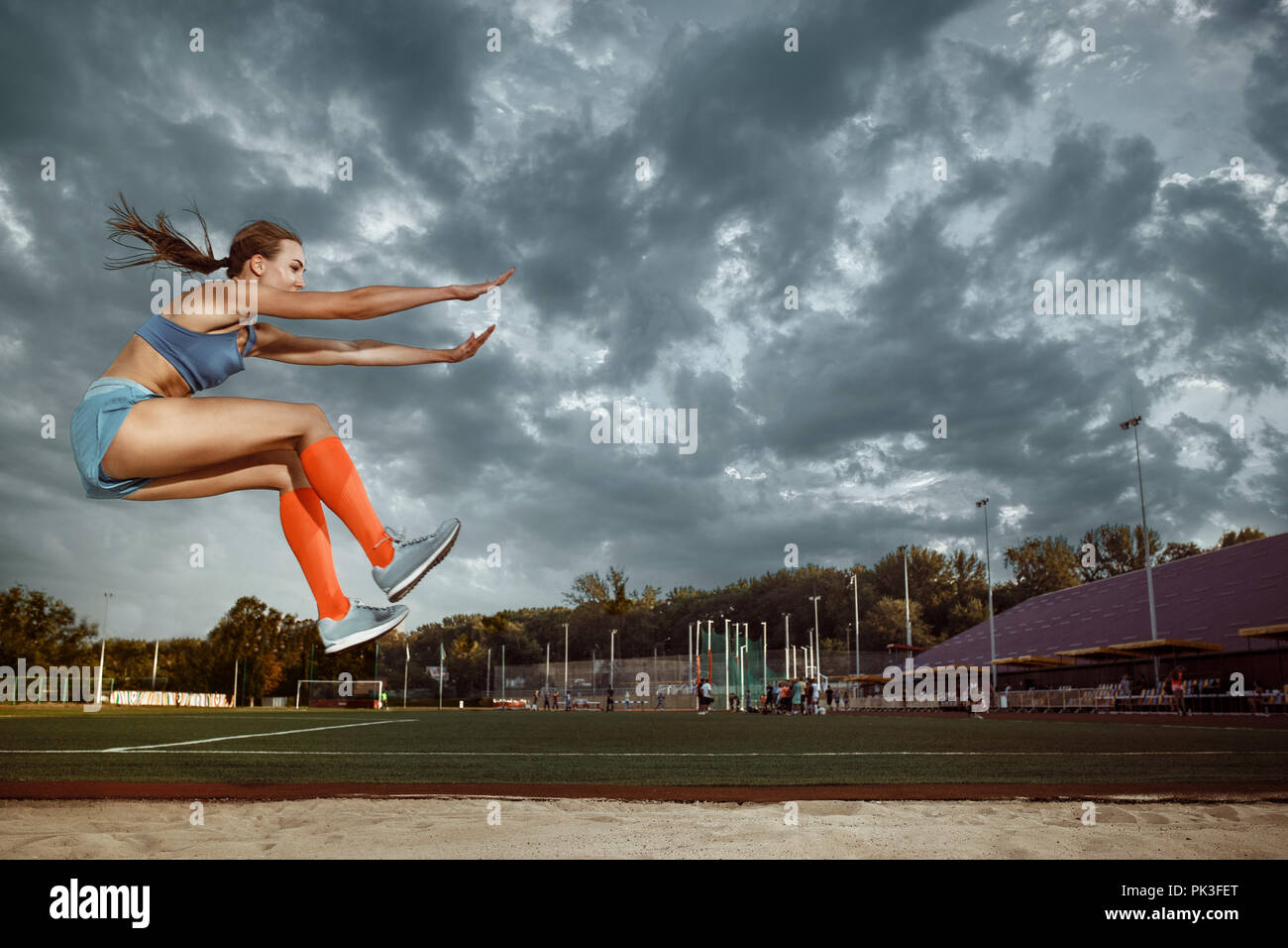 Female athlete performing a long jump during a competition at stadium ...
