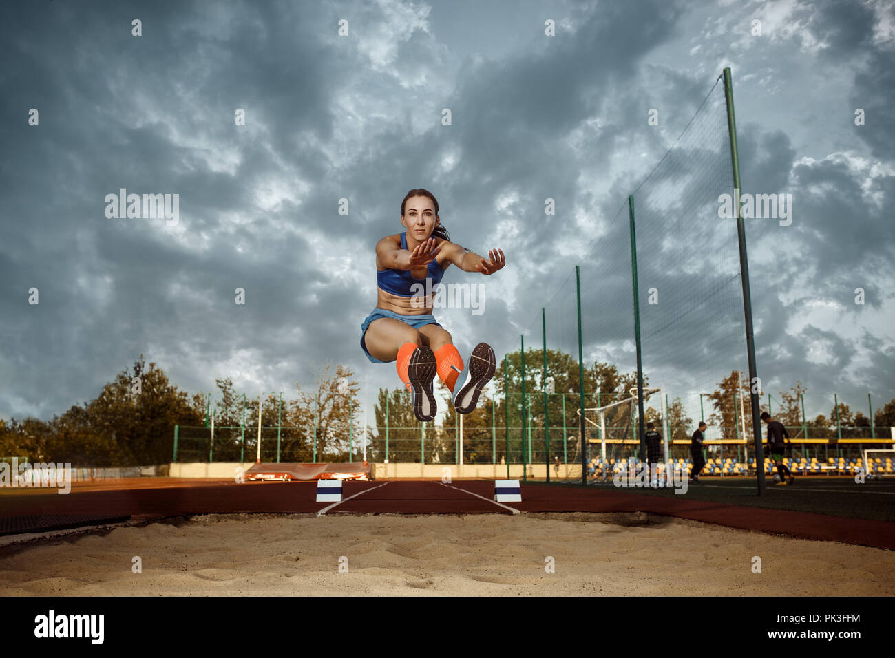 Female athlete performing a long jump during a competition at stadium ...