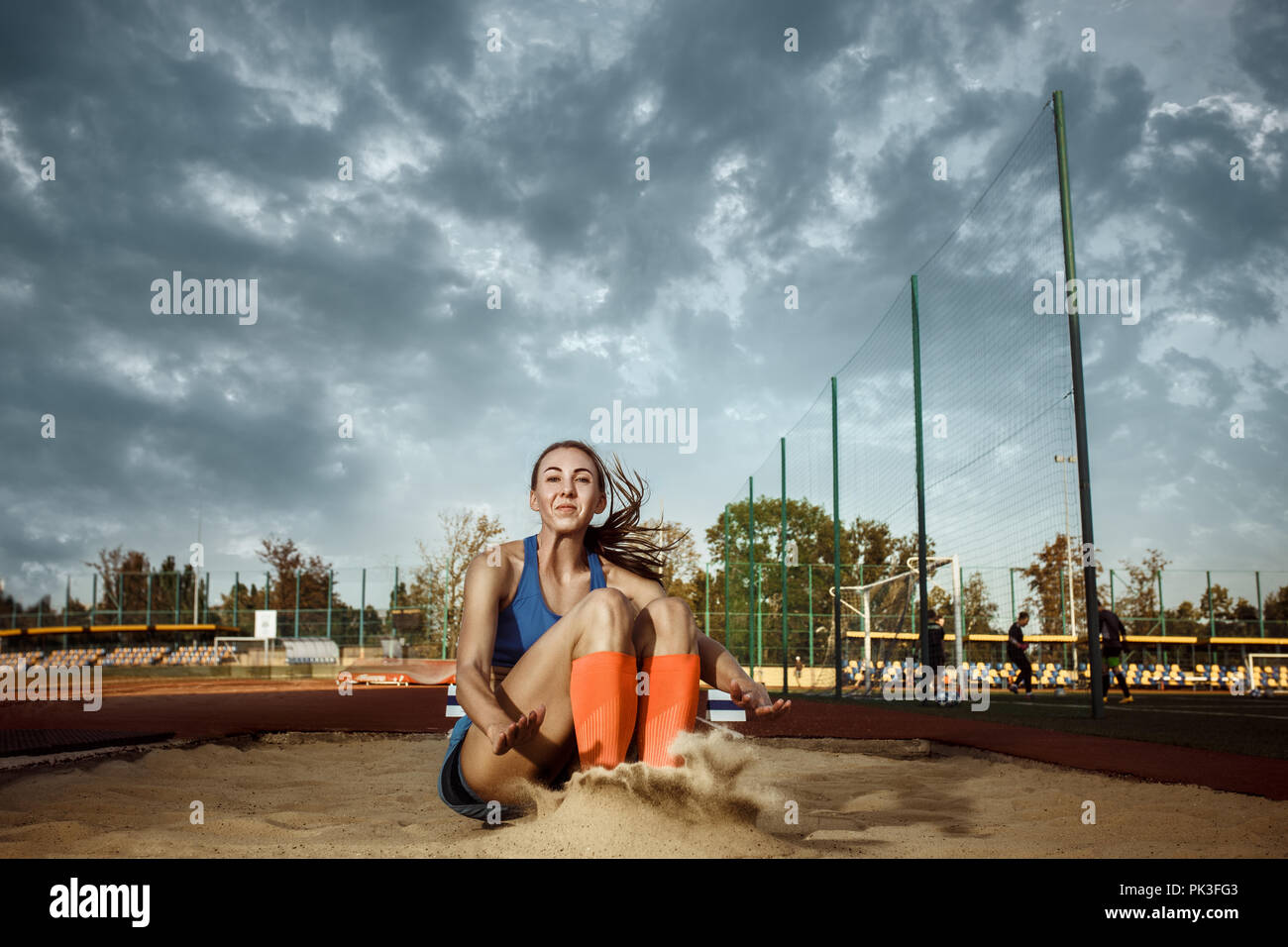 Female athlete performing a long jump during a competition at stadium ...