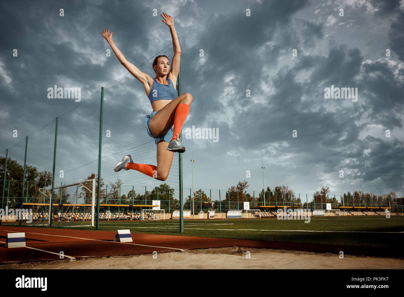 Female athlete performing a long jump during a competition at stadium ...
