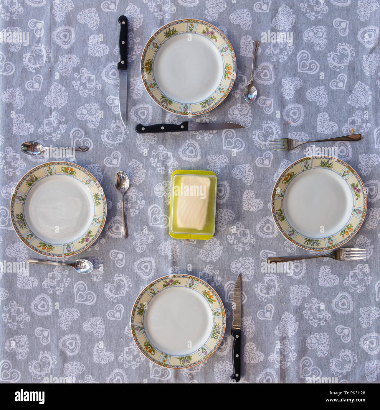 Wrong table set for four persons, dishes, plates with forks, knifes ...