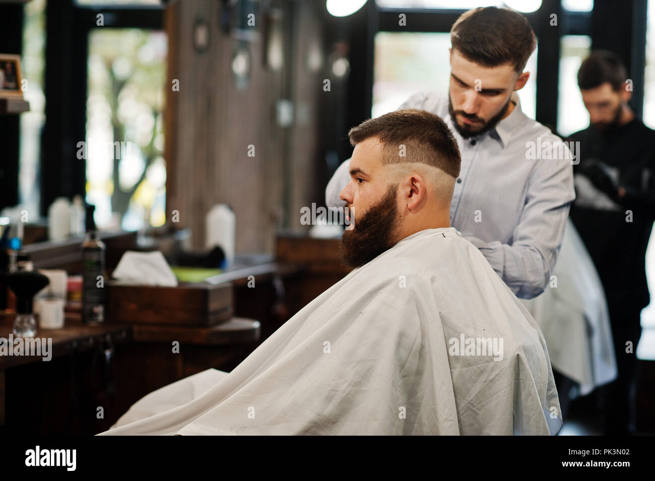Handsome bearded man at the barbershop, barber at work Stock Photo - Alamy
