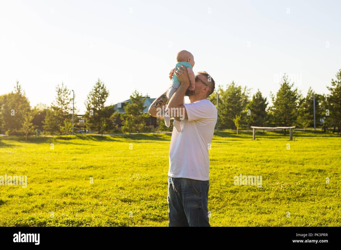 Happy father holding baby son, throwing baby in air. Concept of happy ...