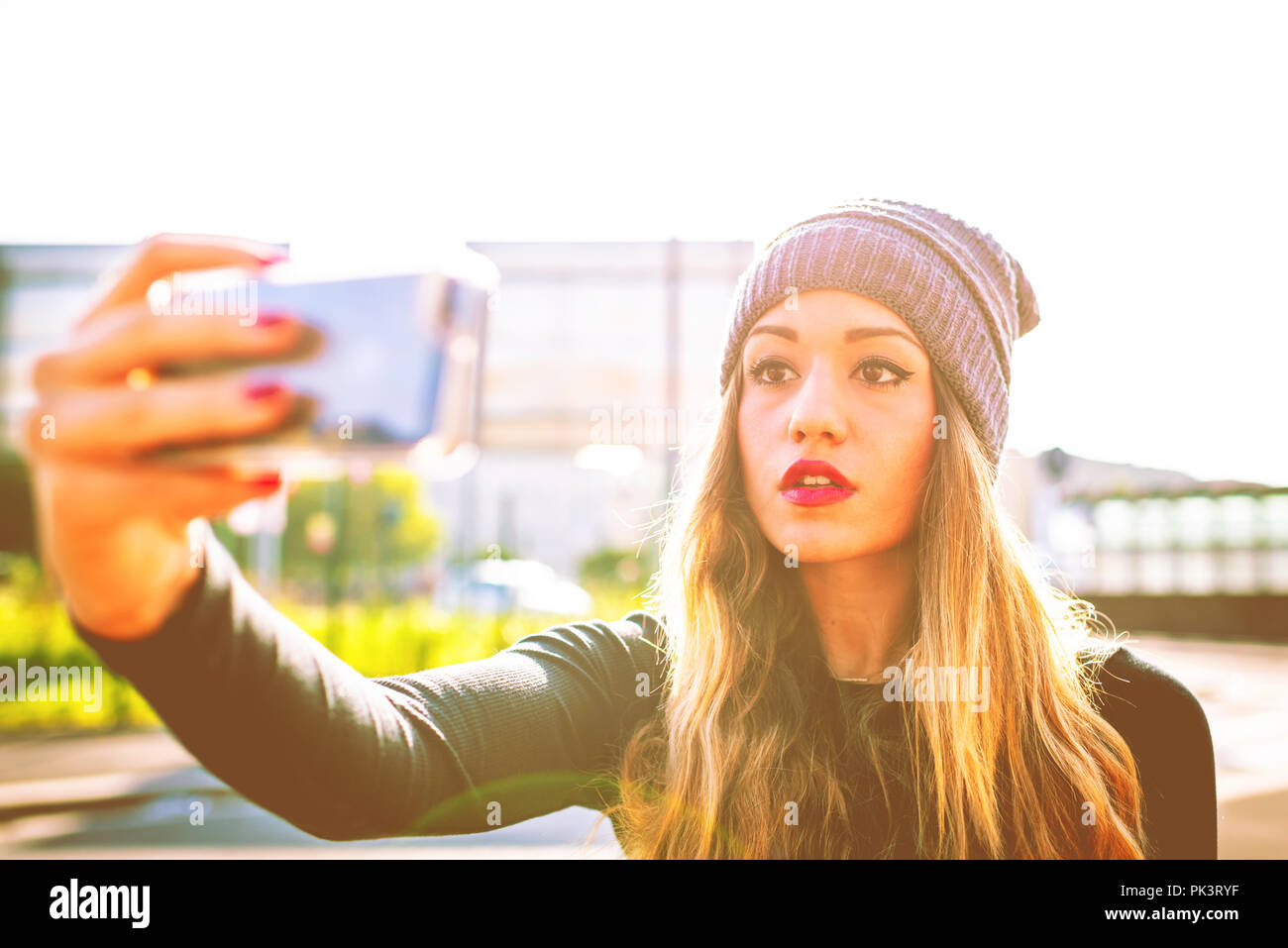 Young Millennial Woman Outdoor Using Smart Phone Taking Selfie