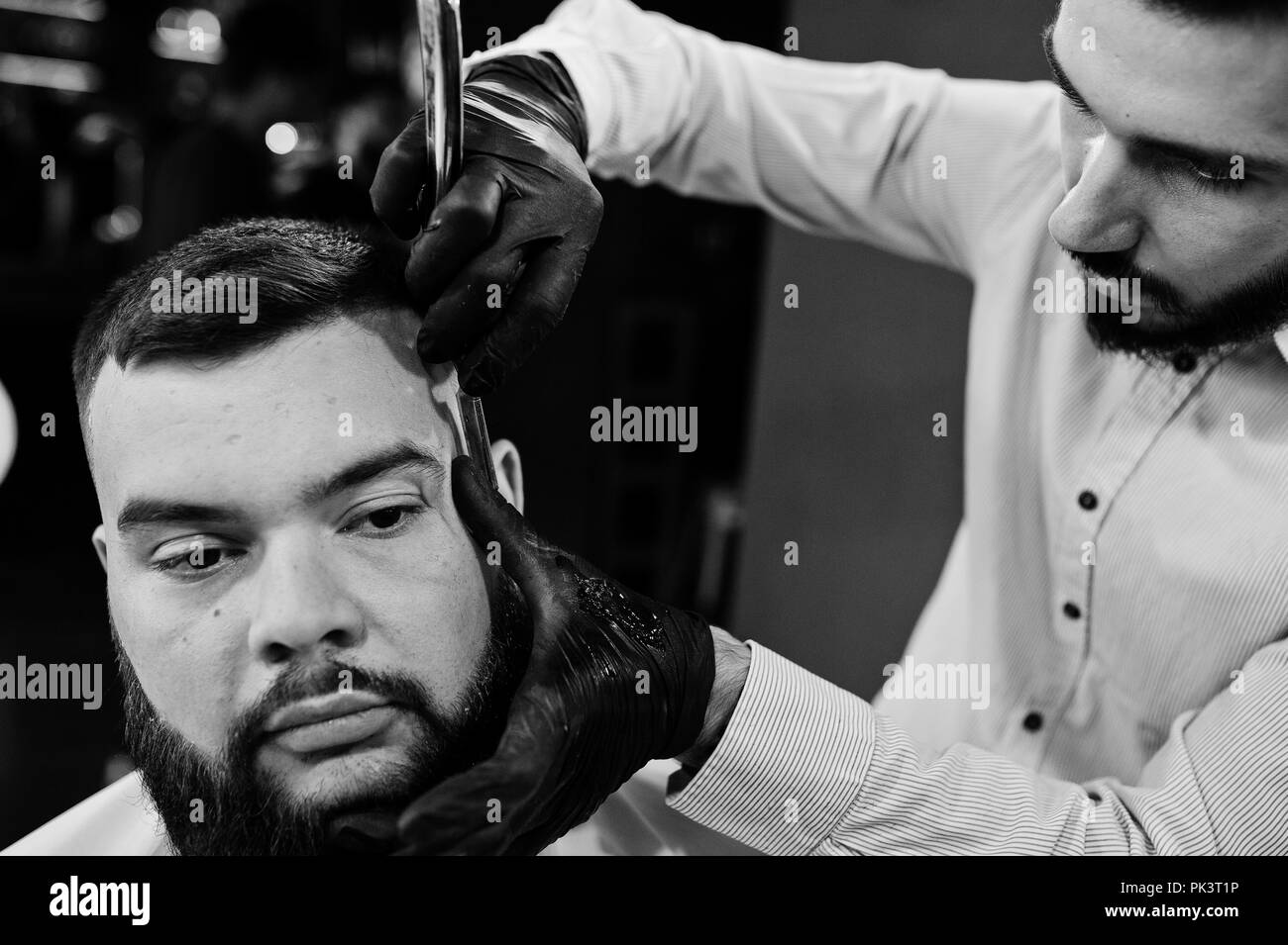 Barber shaving bearded male Black and White Stock Photos & Images - Alamy