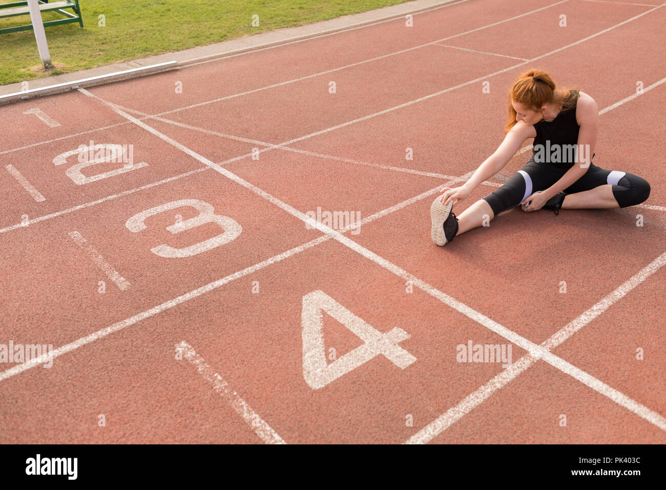 Female athletic exercising on running track Stock Photo - Alamy