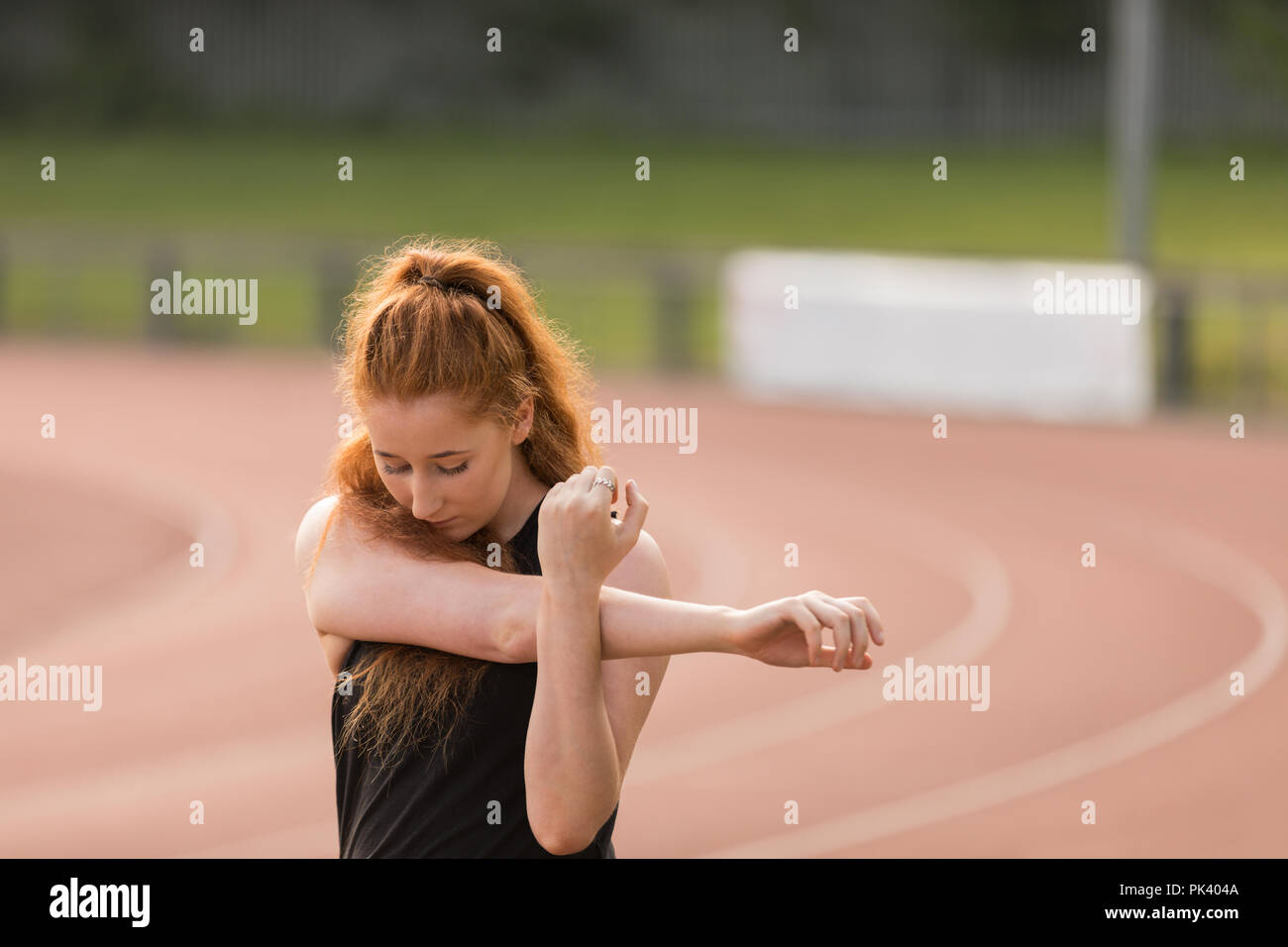 Female athletic exercising on running track Stock Photo - Alamy