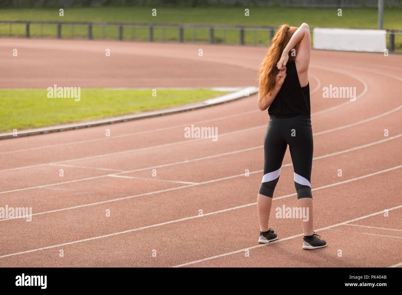 Female athletic exercising on running track Stock Photo - Alamy