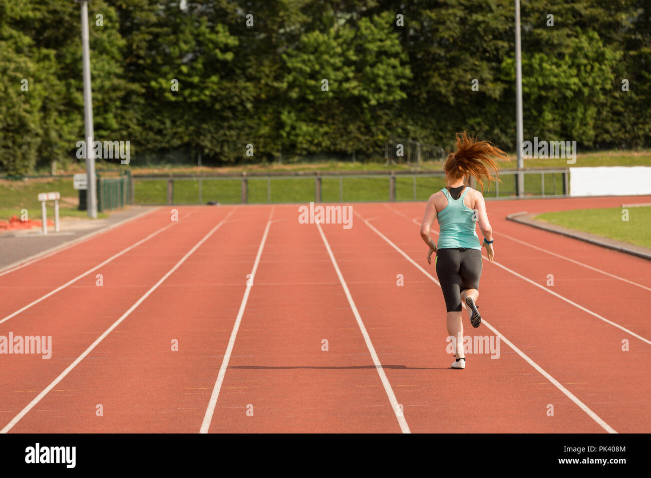 Female athletic running on sports track Stock Photo - Alamy