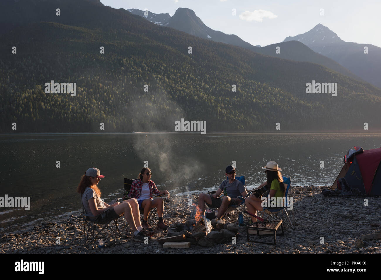 Group of friends camping near riverside Stock Photo - Alamy