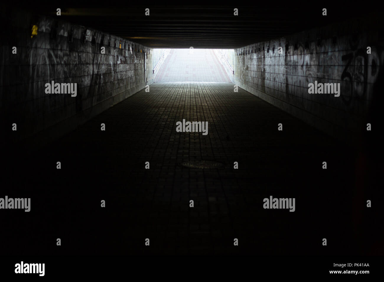 A long concrete tunnel, underground pedestrian crossing in the city ...