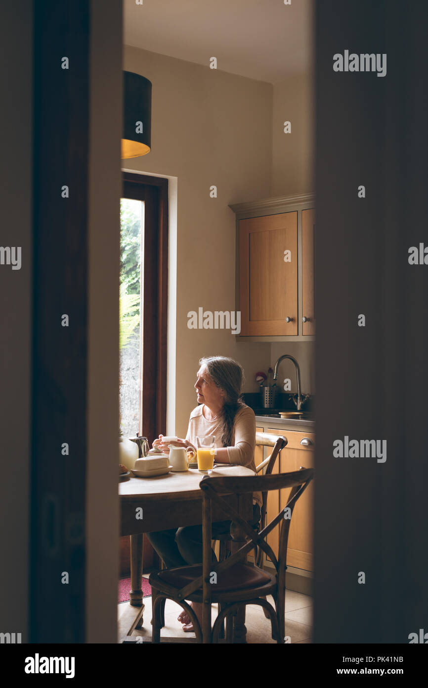 Senior woman having breakfast on dining table Stock Photo - Alamy