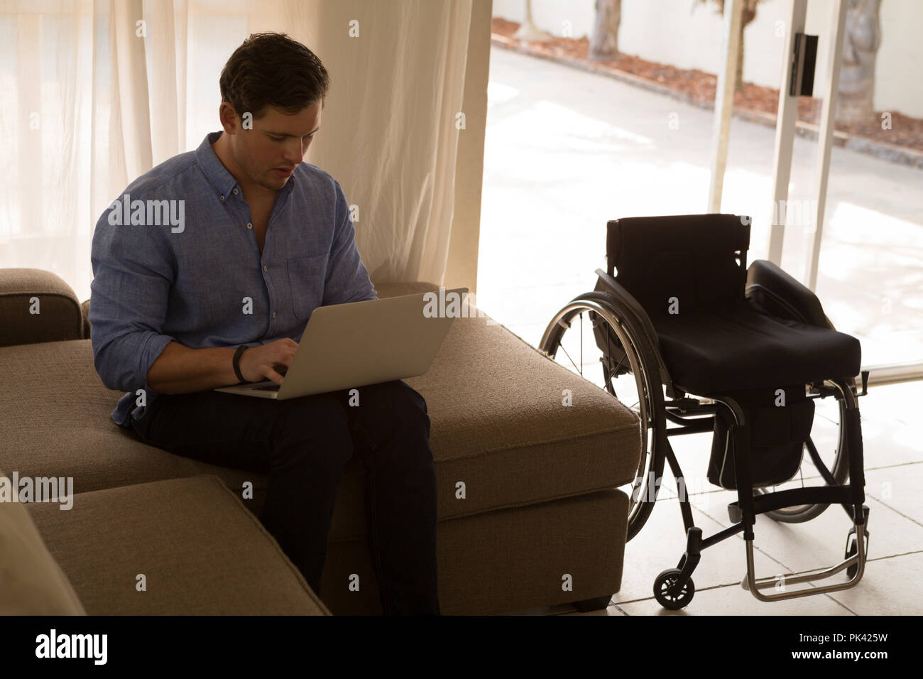 Young man in wheelchair with laptop hi-res stock photography and images ...