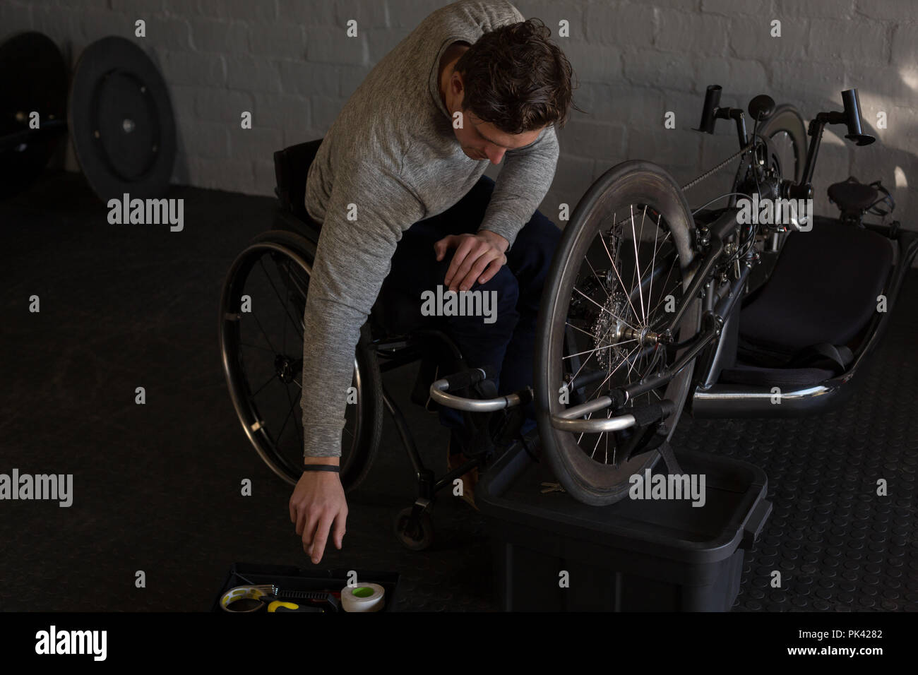 Disabled man repairing wheelchair at workshop Stock Photo - Alamy